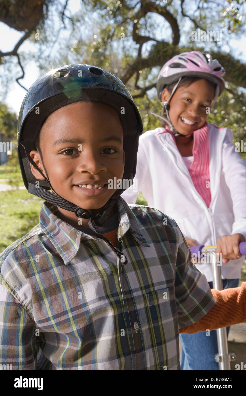 Young African American children riding scooter in park Stock Photo - Alamy