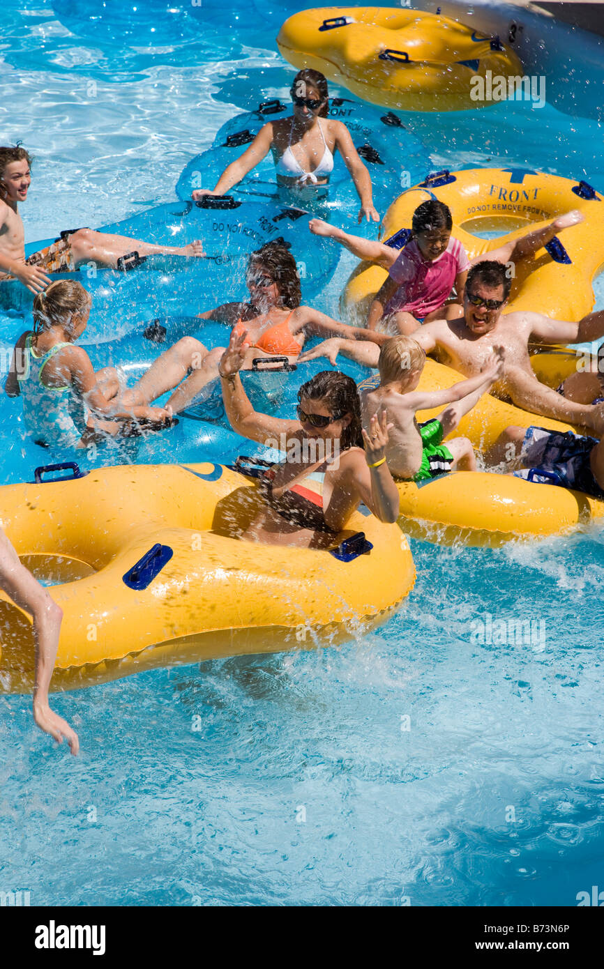 Family and friends splashing on innertubes at water park Stock Photo ...