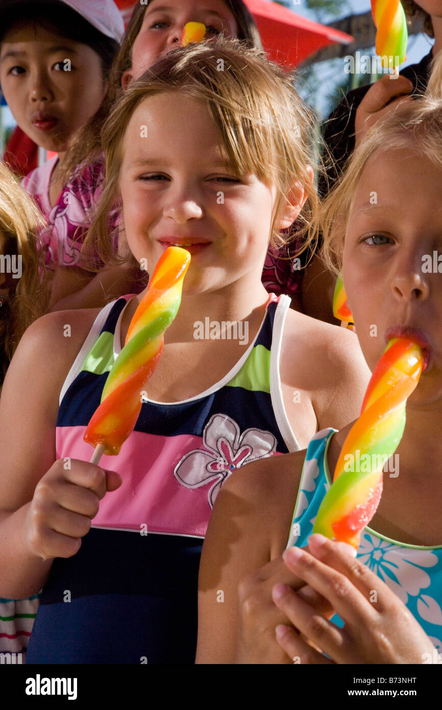Closeup of girls in swimsuits licking popsicles Stock Photo - Alamy
