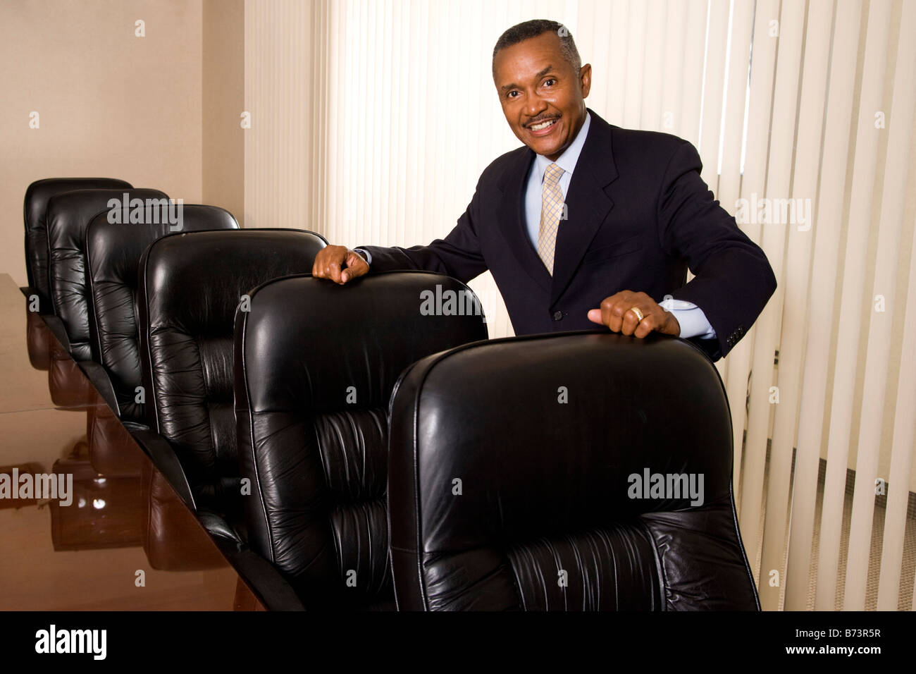 African-American businessman by empty chairs in boardroom Stock Photo ...