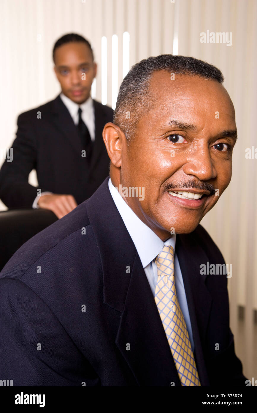 Close-up of African American executive, with younger colleague behind ...