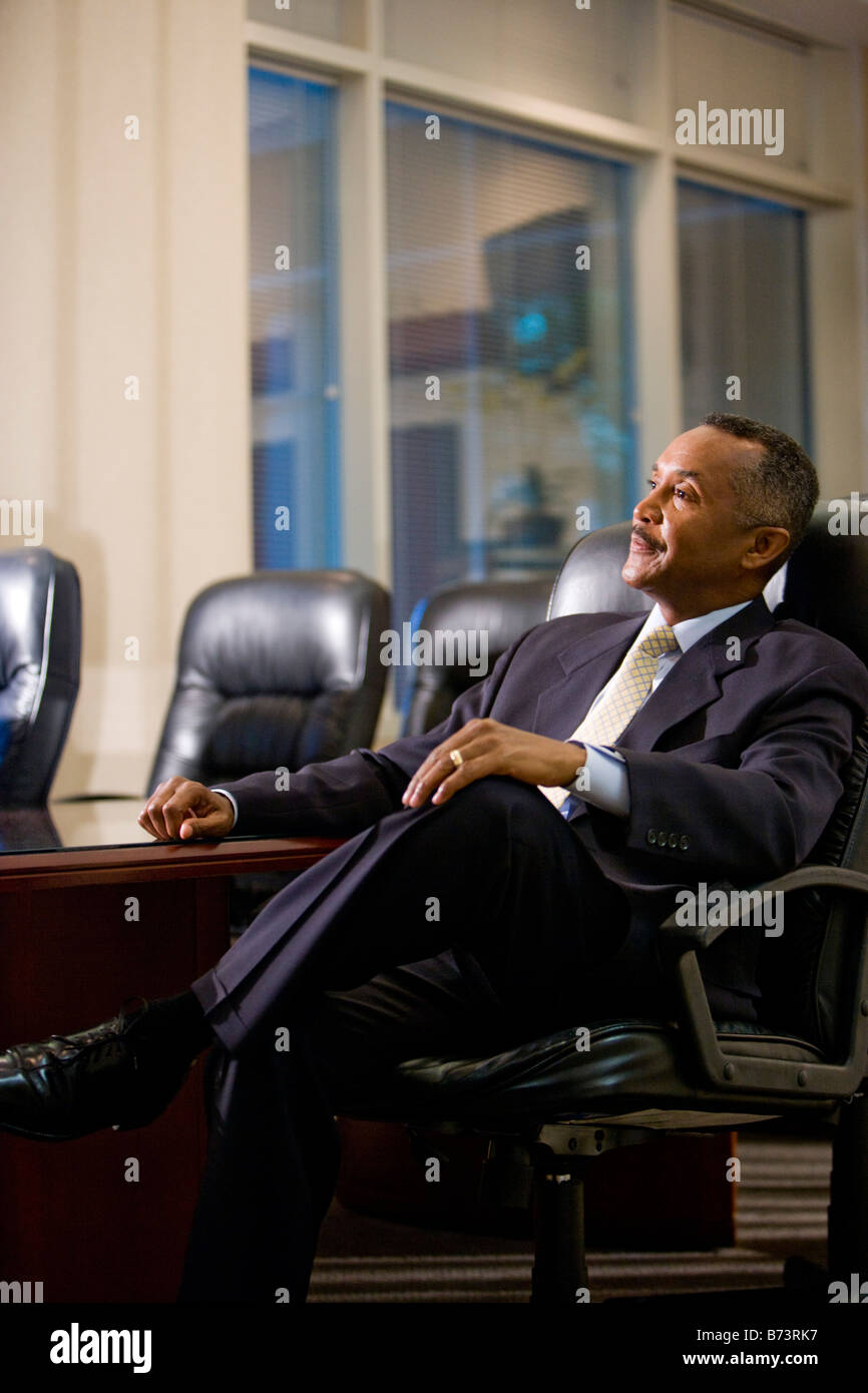 African-American executive sitting in conference room watching Stock ...