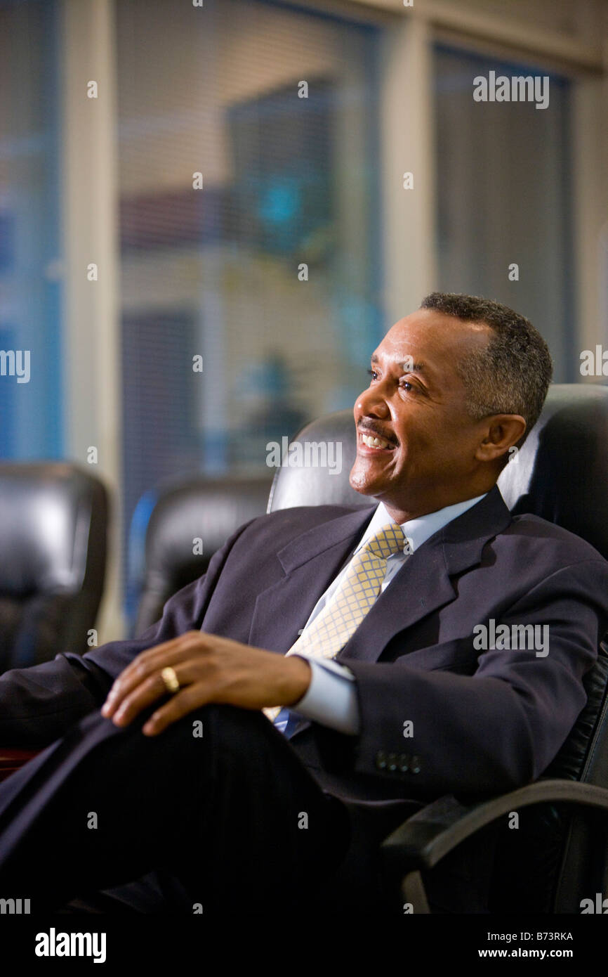 African-American executive sitting in conference room watching Stock ...