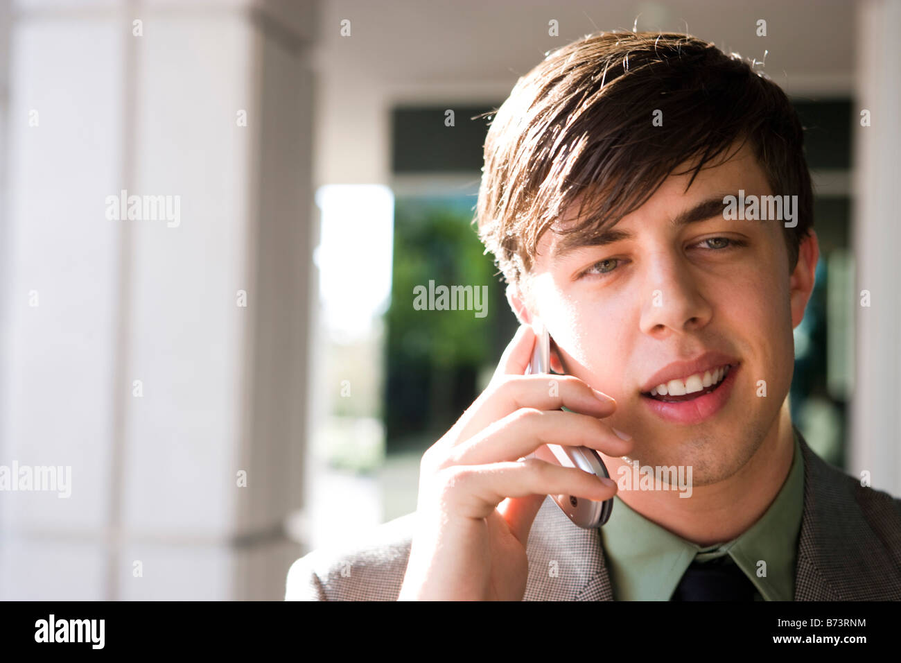 Young man outside building talking on mobile phone Stock Photo - Alamy