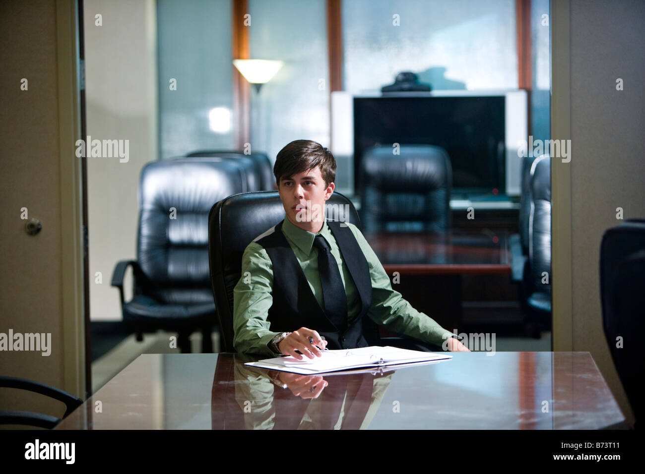 Young office worker sitting alone in conference room Stock Photo - Alamy