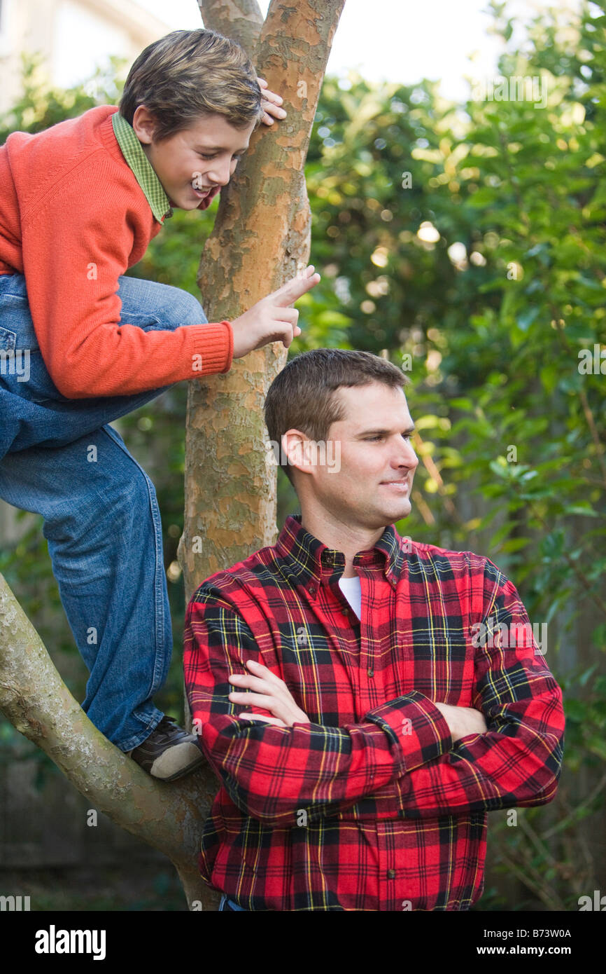 Happy father and son posing around tree in backyard Stock Photo - Alamy