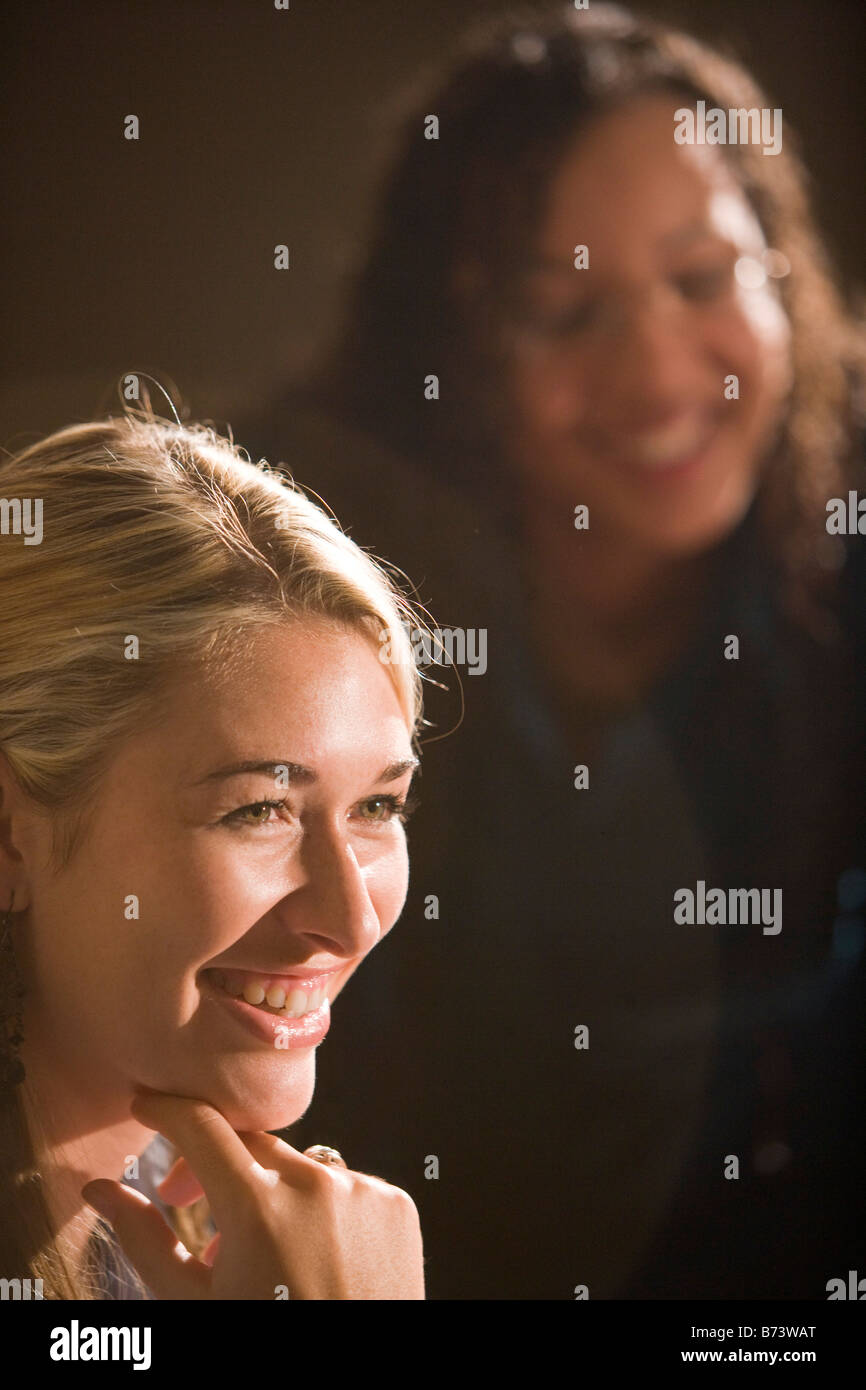 Close-up of young blond woman smiling with friend in background Stock Photo - Alamy