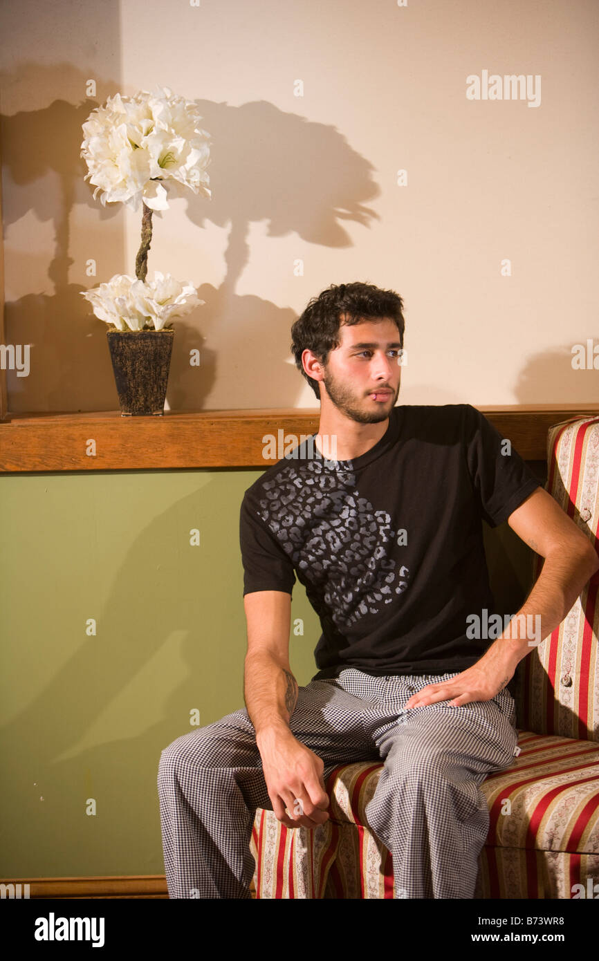 Young man with lip piercing sitting in living room Stock Photo - Alamy