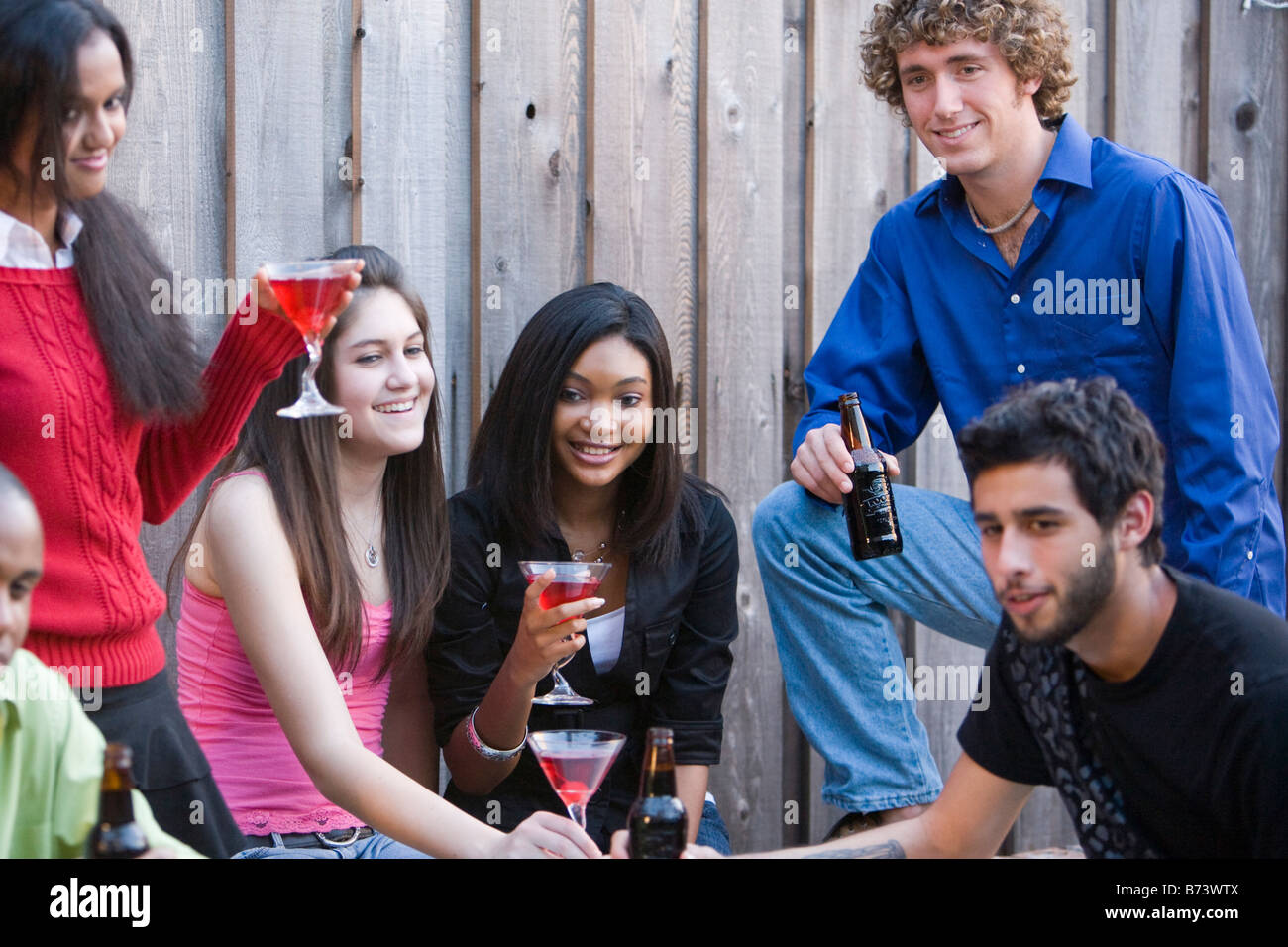 Group of young friends drinking and socializing Stock Photo - Alamy