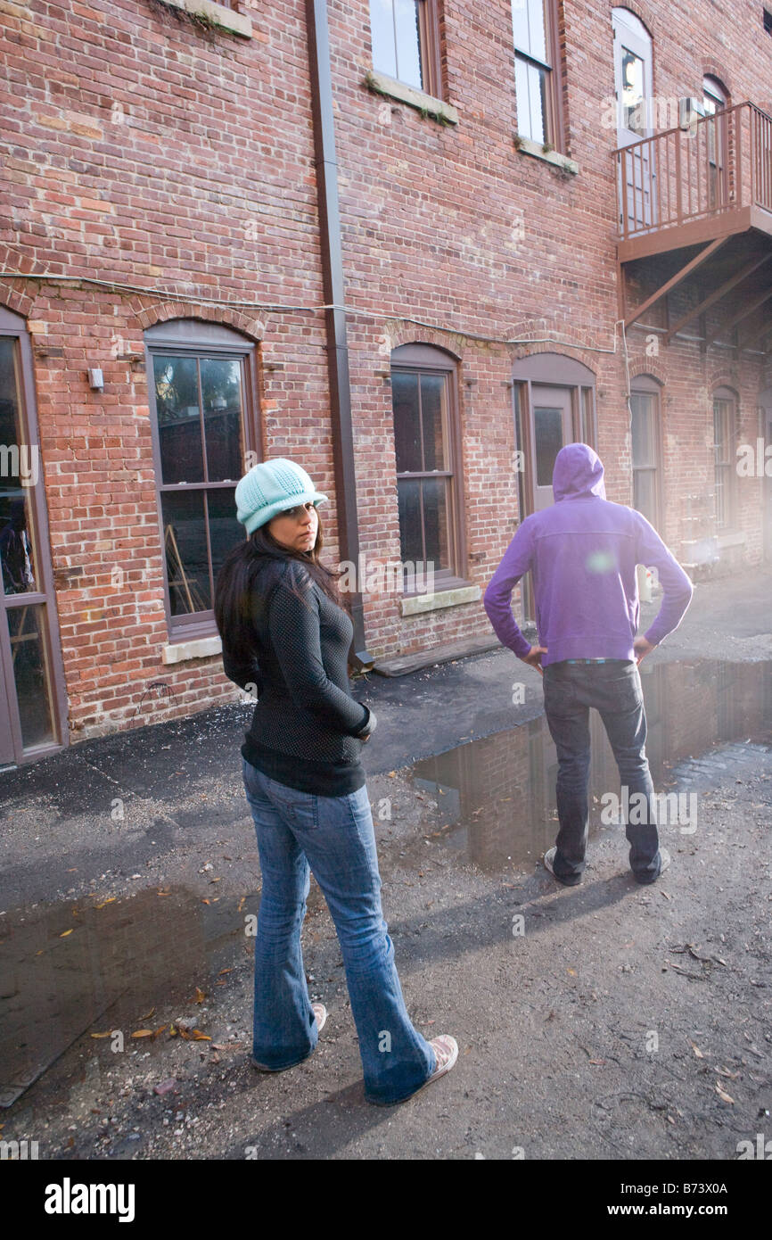 Young couple hanging out in back alley Stock Photo - Alamy