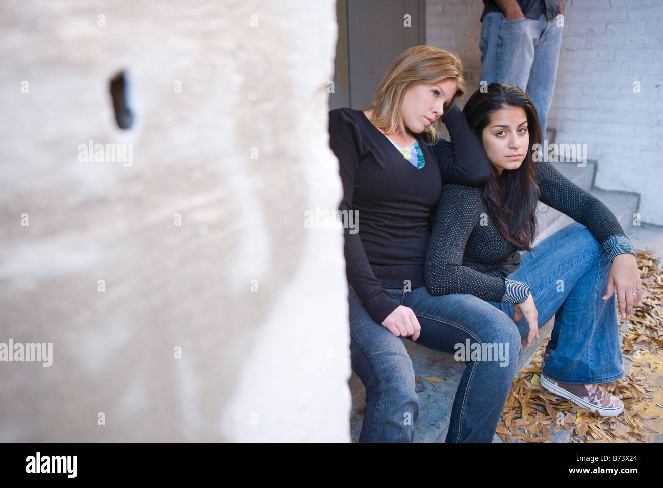 Two bored young women hanging out on steps of old building Stock Photo ...