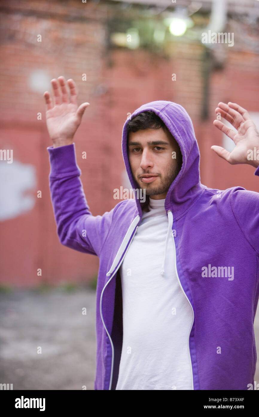 Young man wearing hoodie with arms raised Stock Photo - Alamy