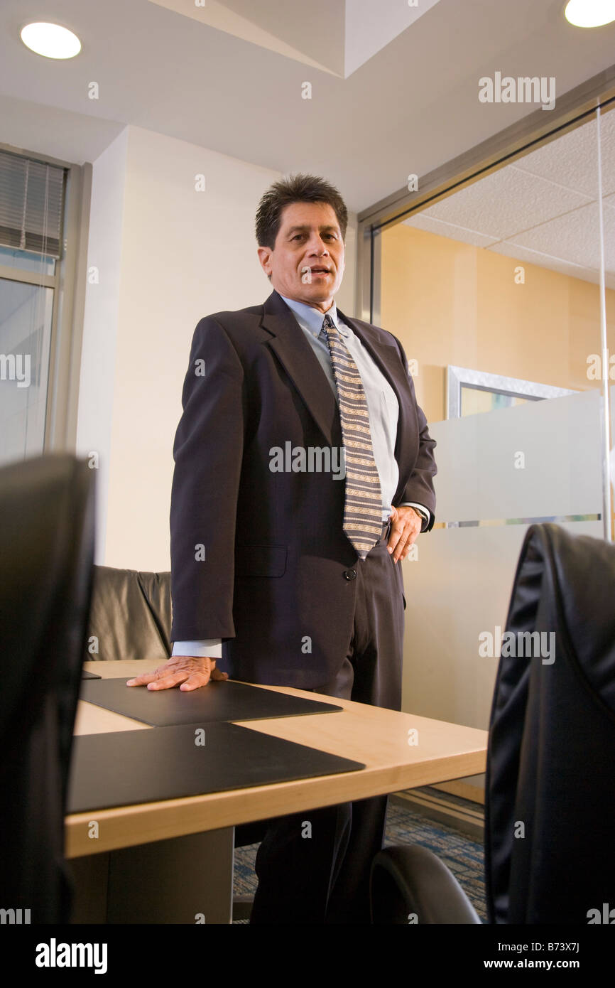Hispanic businessman standing by table in boardroom Stock Photo - Alamy