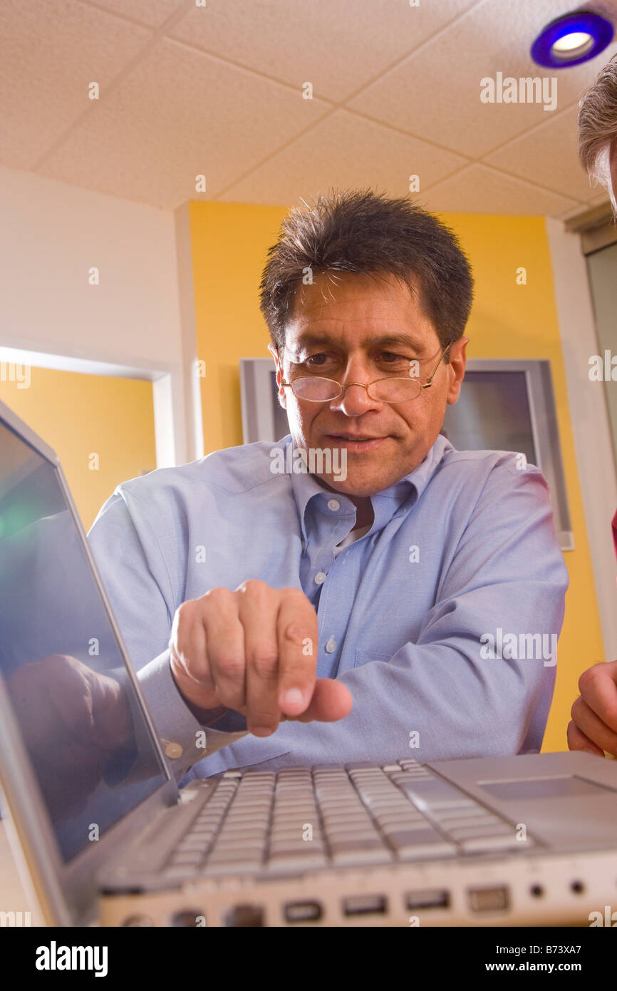 Middle aged businessman using laptop in the lobby Stock Photo - Alamy