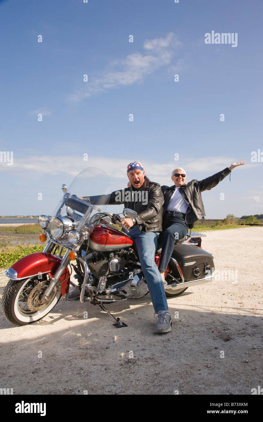 Portrait of happy senior biker couple sitting on motorcycle Stock Photo ...