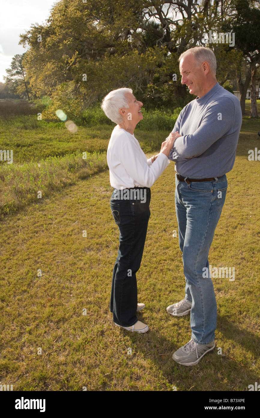 Affectionate senior couple standing face to face on grass in park Stock ...