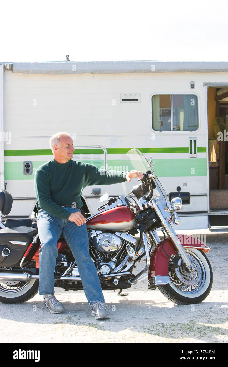 Senior biker man sitting on motorcycle in front of RV camper Stock ...