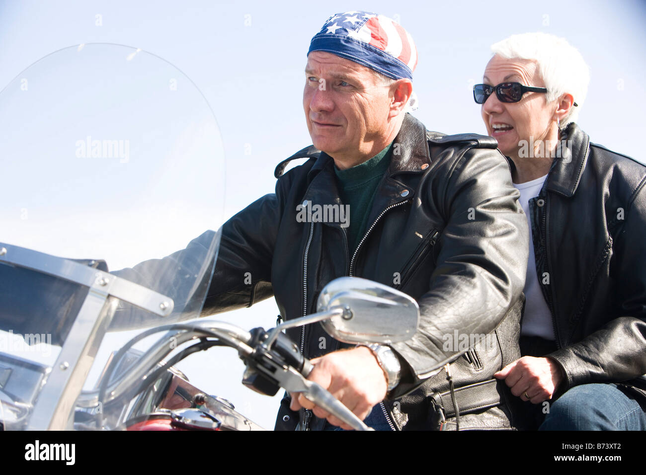 Happy senior biker couple riding motorcyle in leather jackets Stock ...