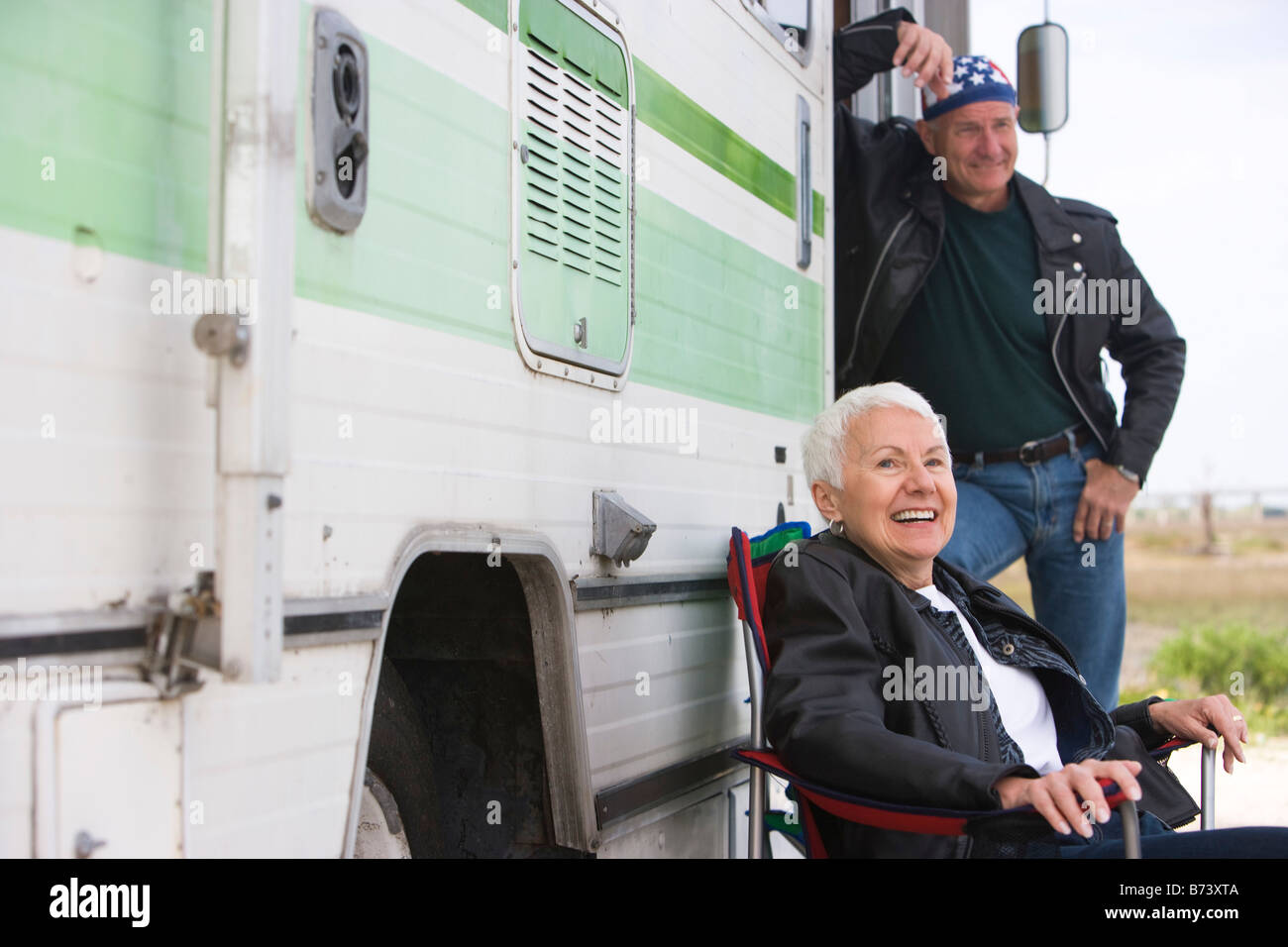Happy senior couple outside RV camper Stock Photo - Alamy
