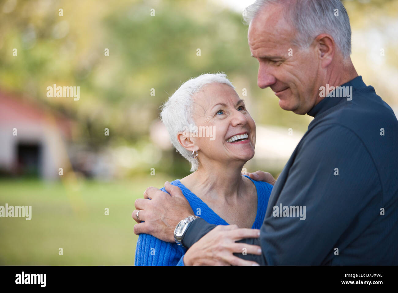Side view of senior couple embracing outdoors, smiling Stock Photo - Alamy