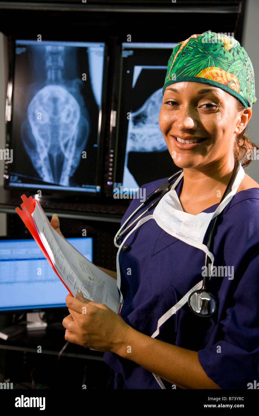 Veterinarian holding medical chart with animal x-rays in background ...