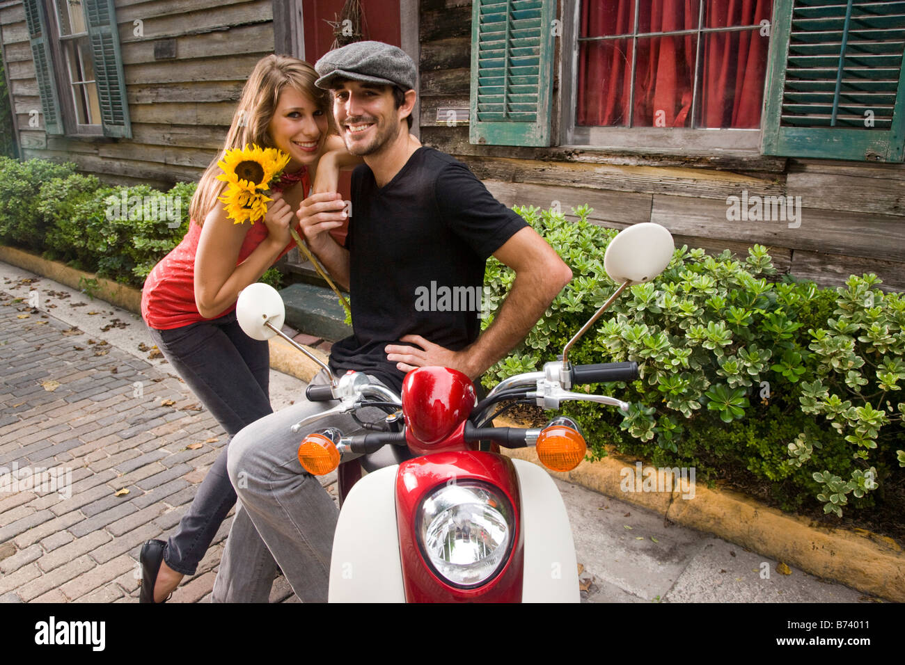 Young romantic couple on scooter on cobblestone road Stock Photo - Alamy