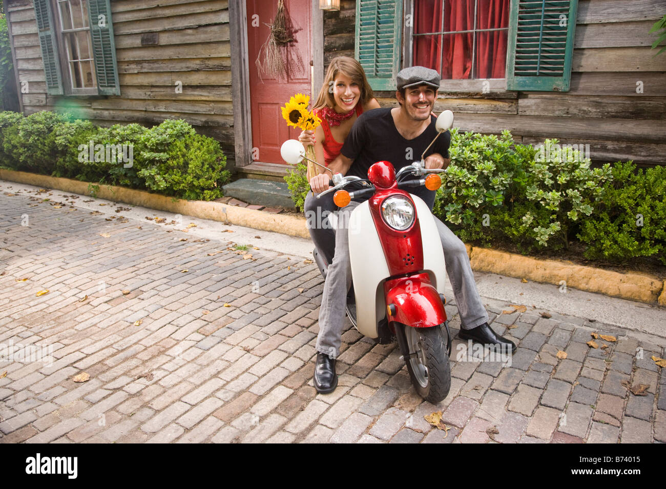 Young romantic couple on scooter on cobblestone road Stock Photo - Alamy