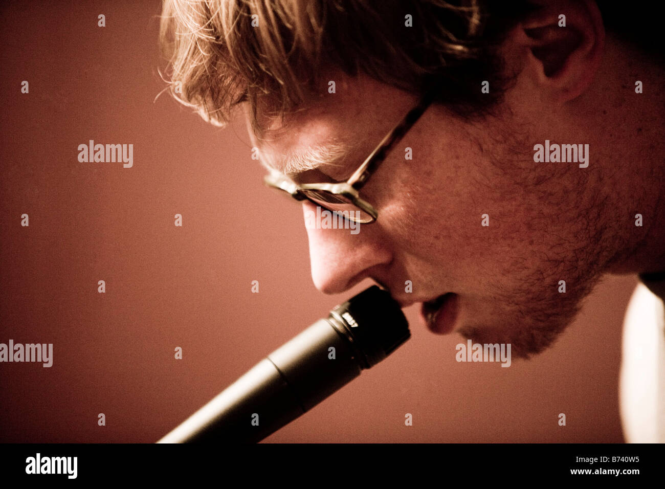 Close-up of young man singing into microphone Stock Photo - Alamy
