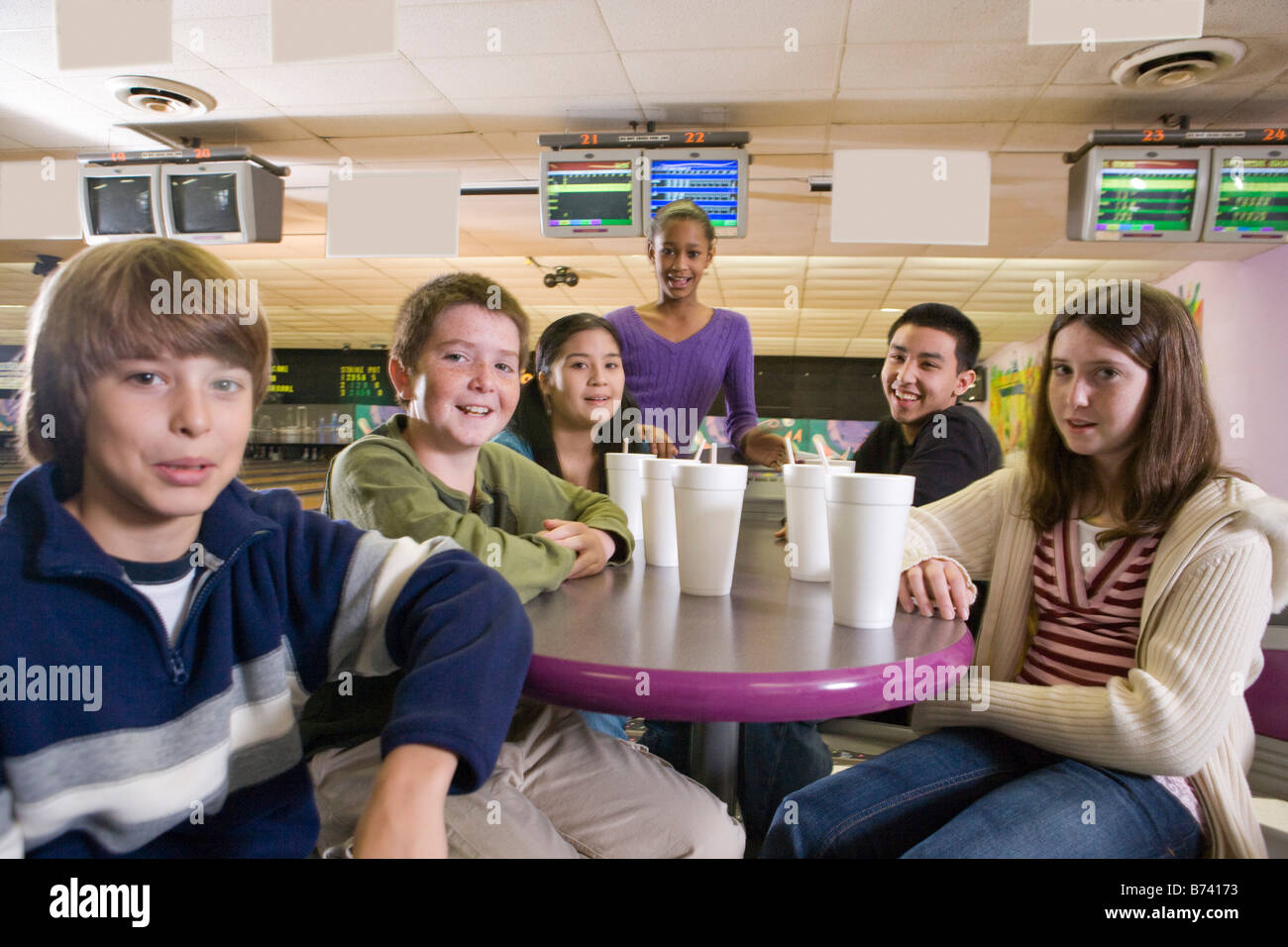 Multi-racial children sitting around table in bowling alley Stock Photo ...
