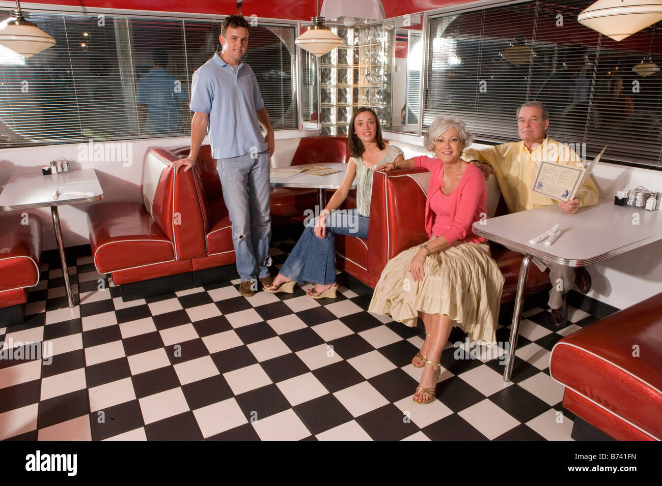 Young couple with parents sitting in booth of old-fashioned diner Stock ...