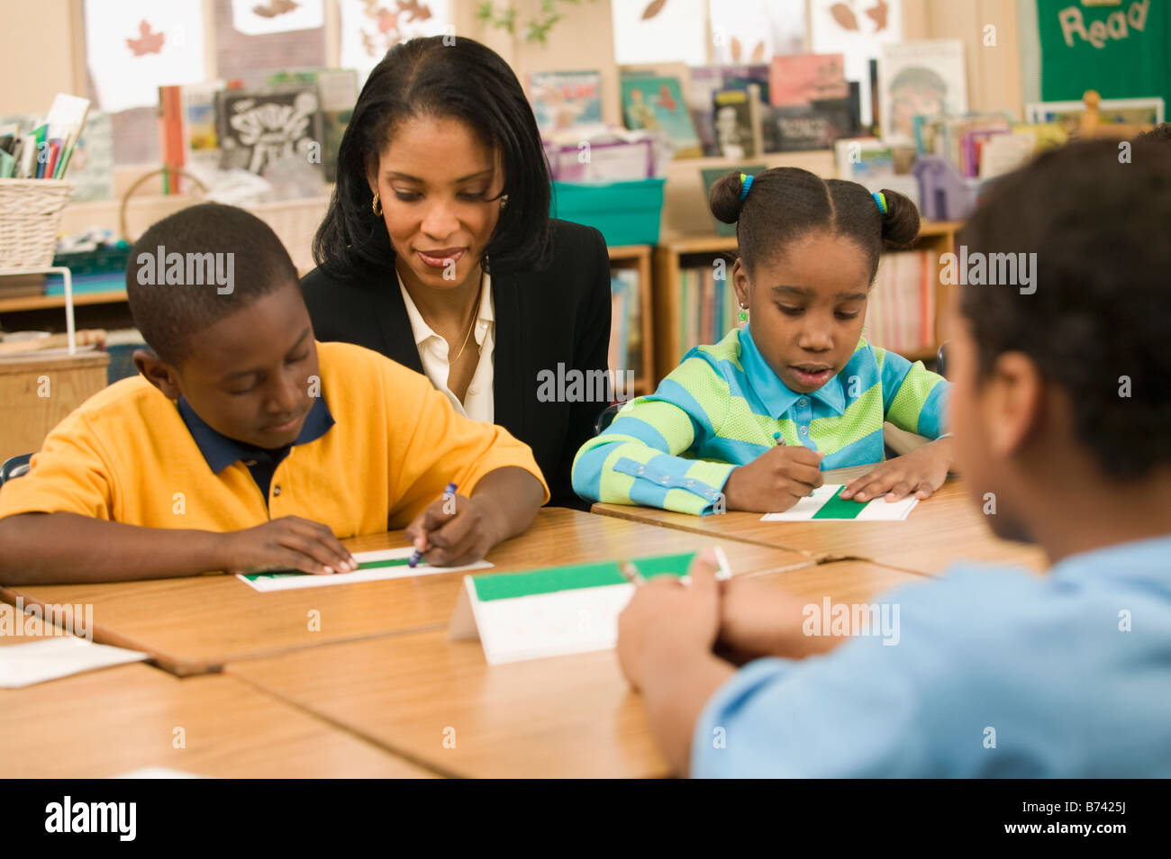 African school teacher helping students Stock Photo - Alamy