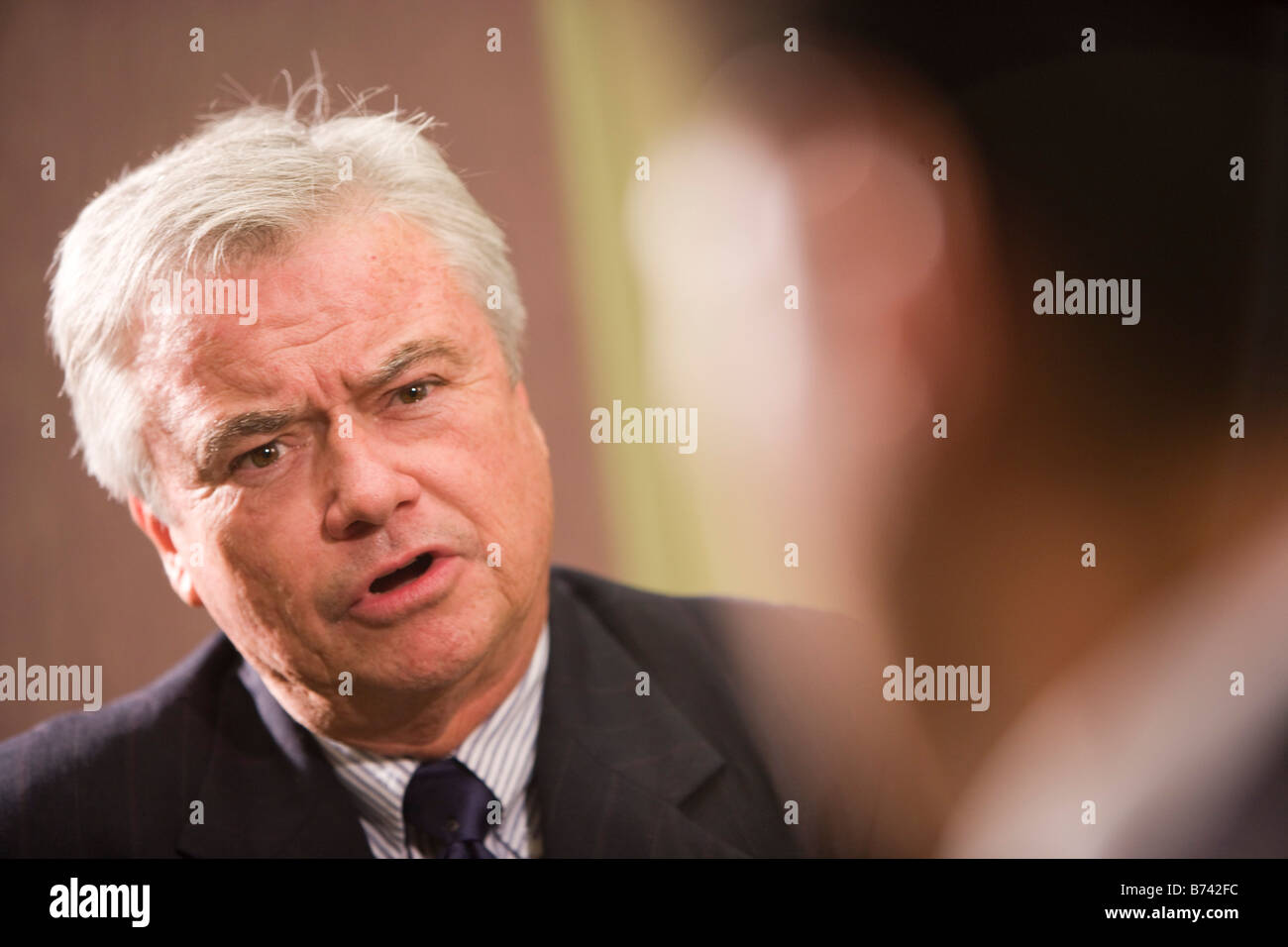 Two businessmen in serious discussion, focus on man in background Stock ...