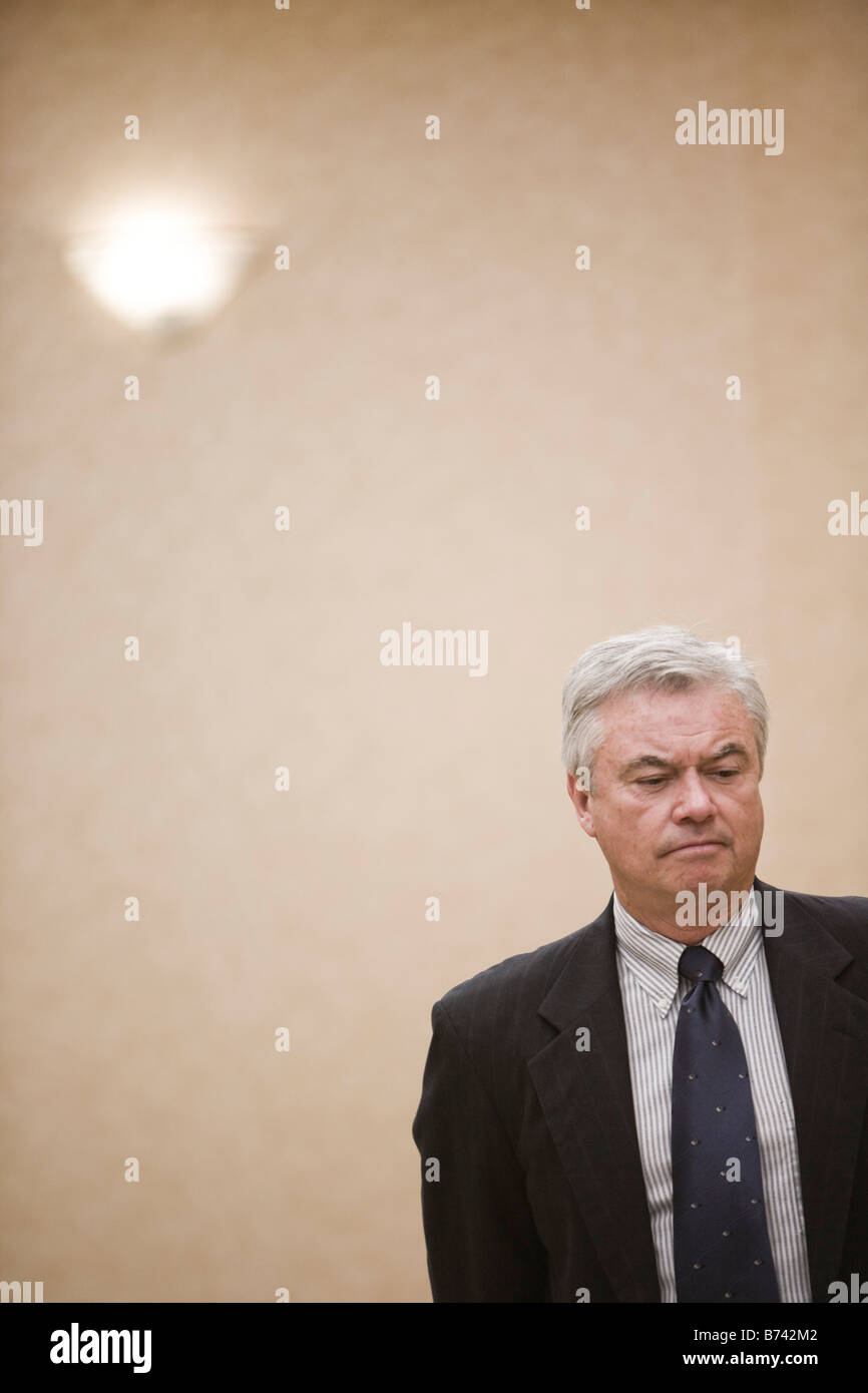 Mature businessman standing in office, looking down Stock Photo - Alamy