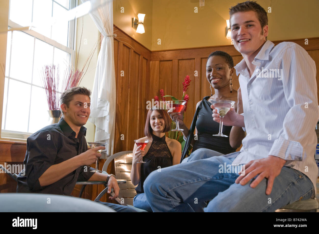 Two young couples drinking and socializing in restaurant lounge Stock ...