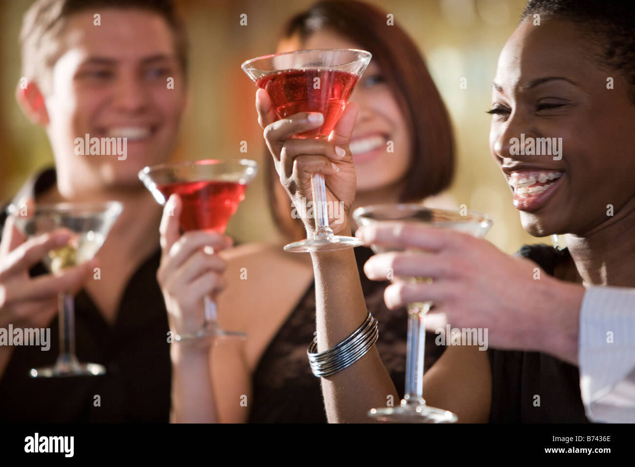 Young African-American woman drinking and socializing with friends ...