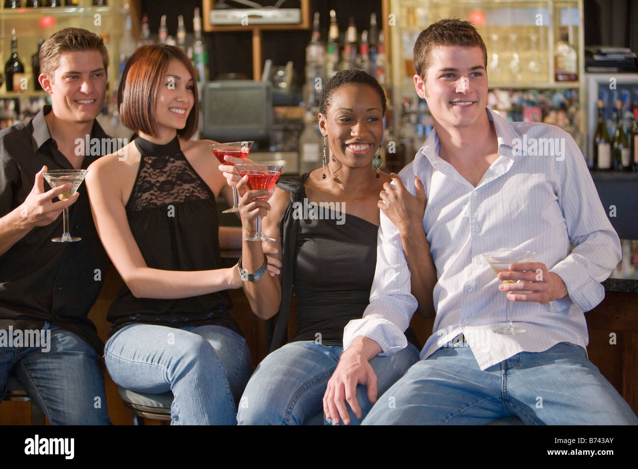 Two young couples drinking together at restaurant bar Stock Photo - Alamy