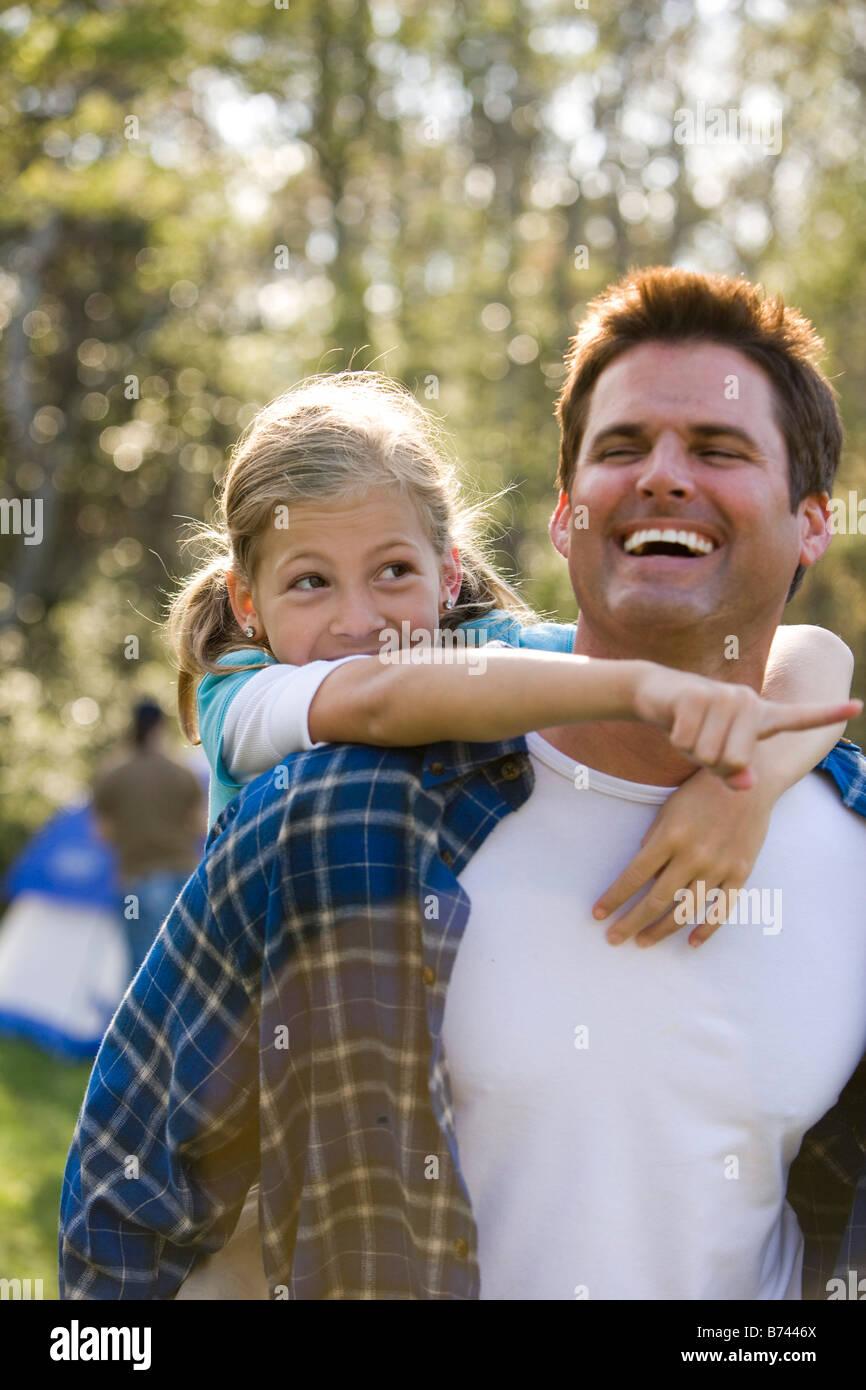 Father giving girl piggyback ride in park Stock Photo - Alamy