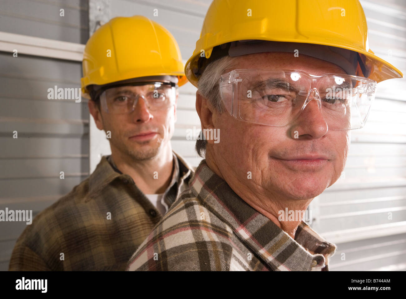 Male construction workers wearing hard hats Stock Photo - Alamy