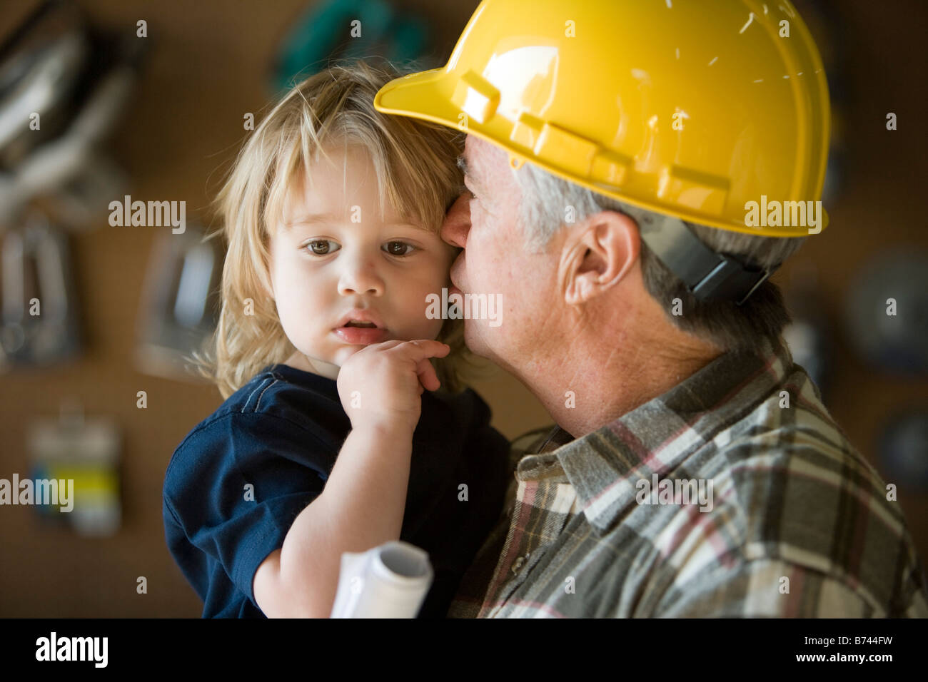 Grandfather in hard hat kissing grandson on cheek Stock Photo - Alamy