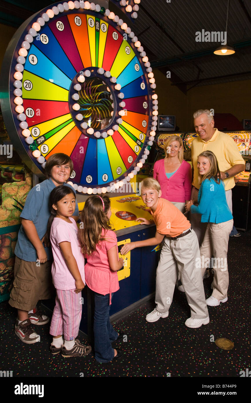 Family and friends playing an arcade game at an amusement park Stock ...