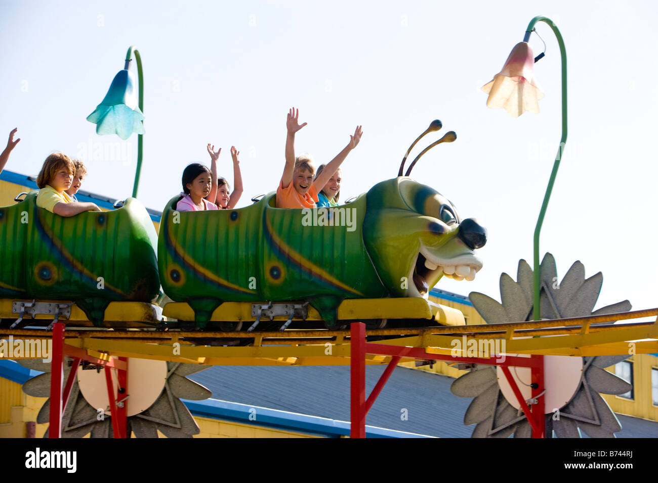 Children riding a roller coaster in an amusement park Stock Photo - Alamy