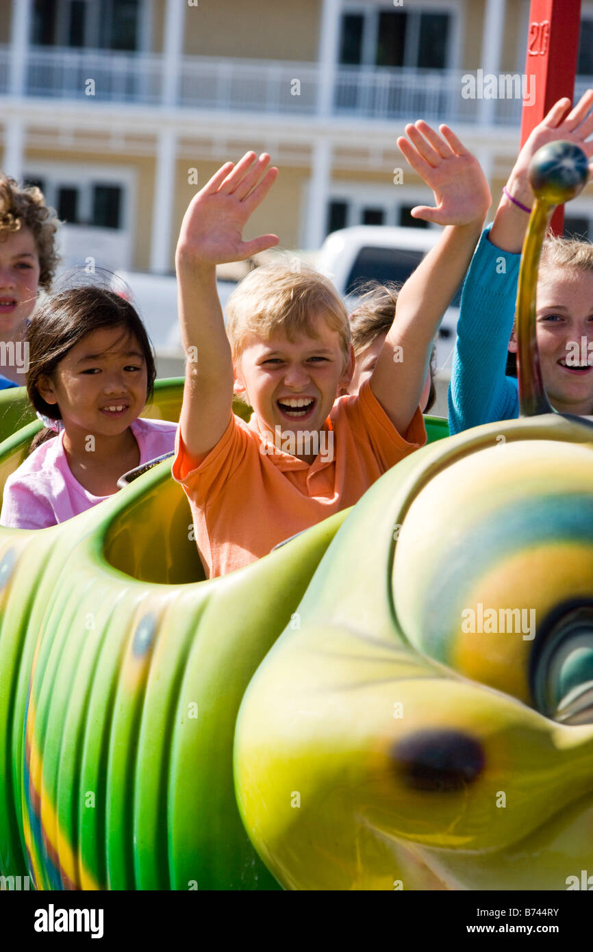 Children riding a roller coaster in an amusement park Stock Photo - Alamy