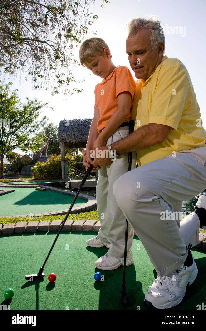 Father teaching son to putt at miniature golf course Stock Photo - Alamy
