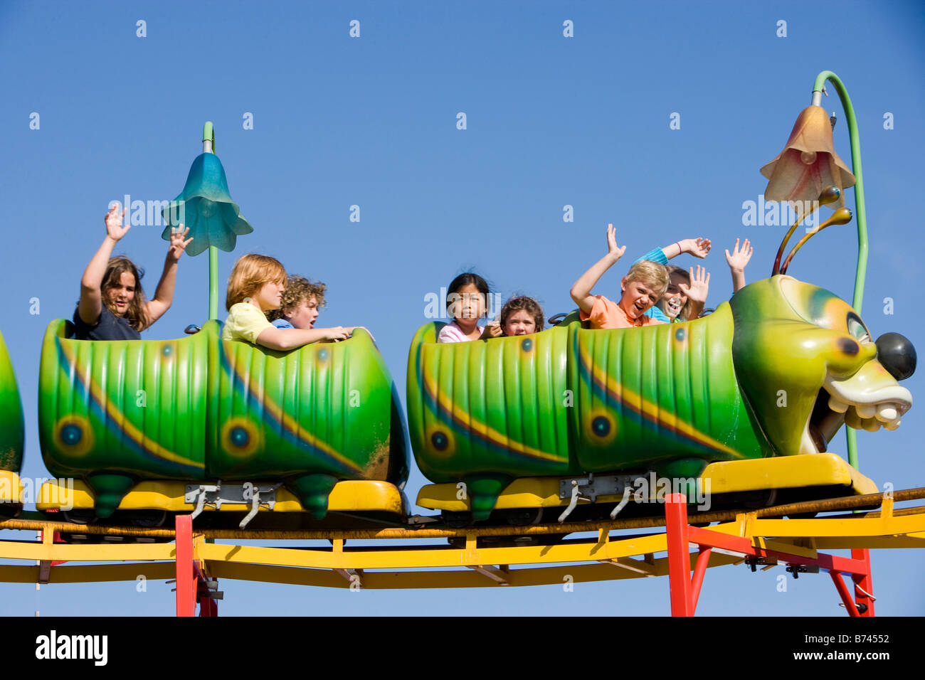 Children riding a rollercoaster at amusement park Stock Photo - Alamy