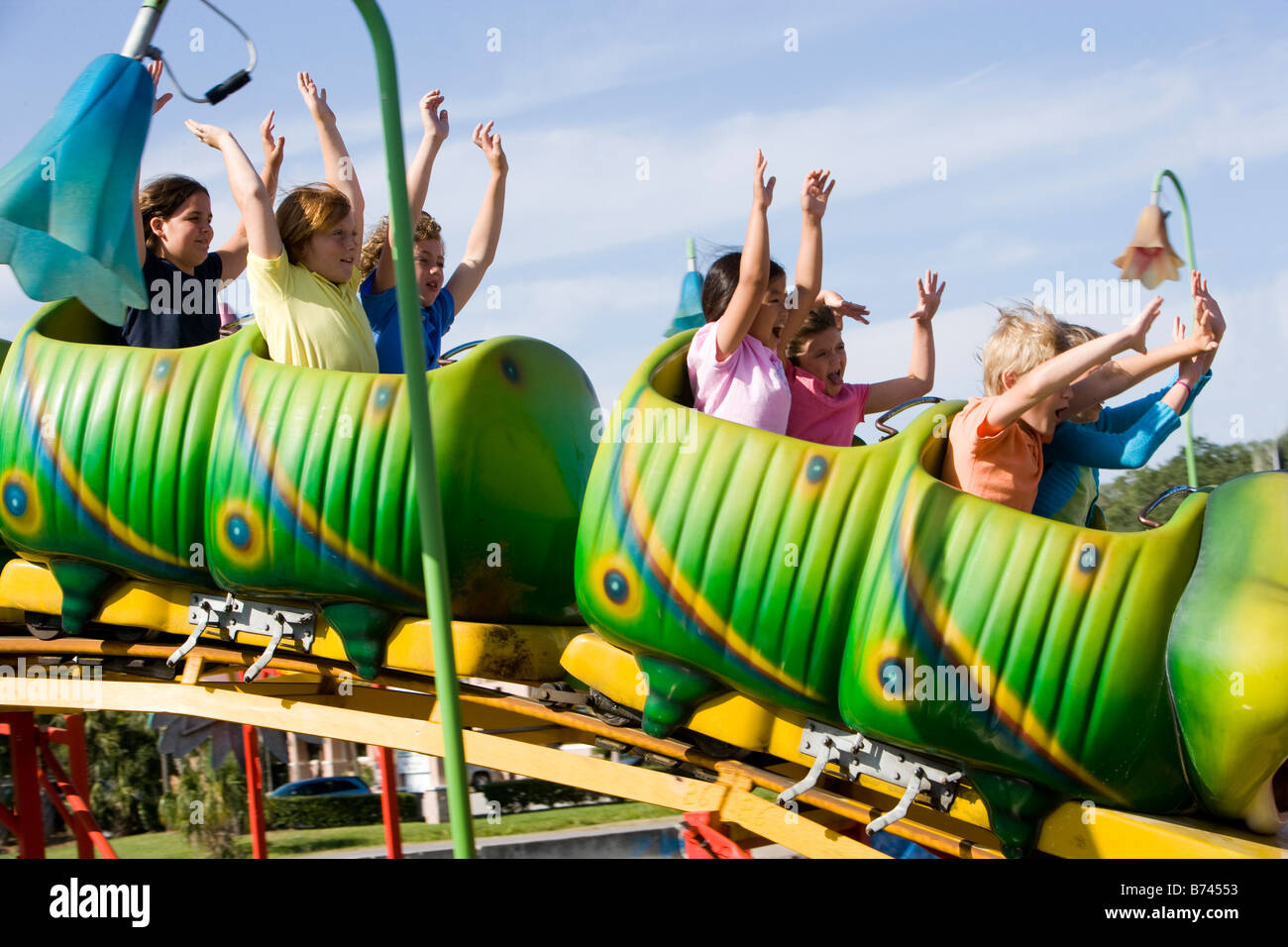 Children riding a rollercoaster at amusement park Stock Photo - Alamy