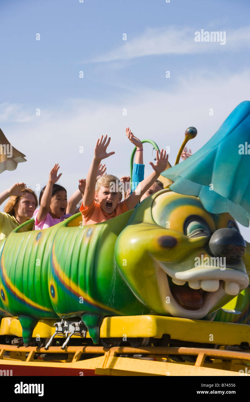 Children riding a rollercoaster at amusement park Stock Photo - Alamy