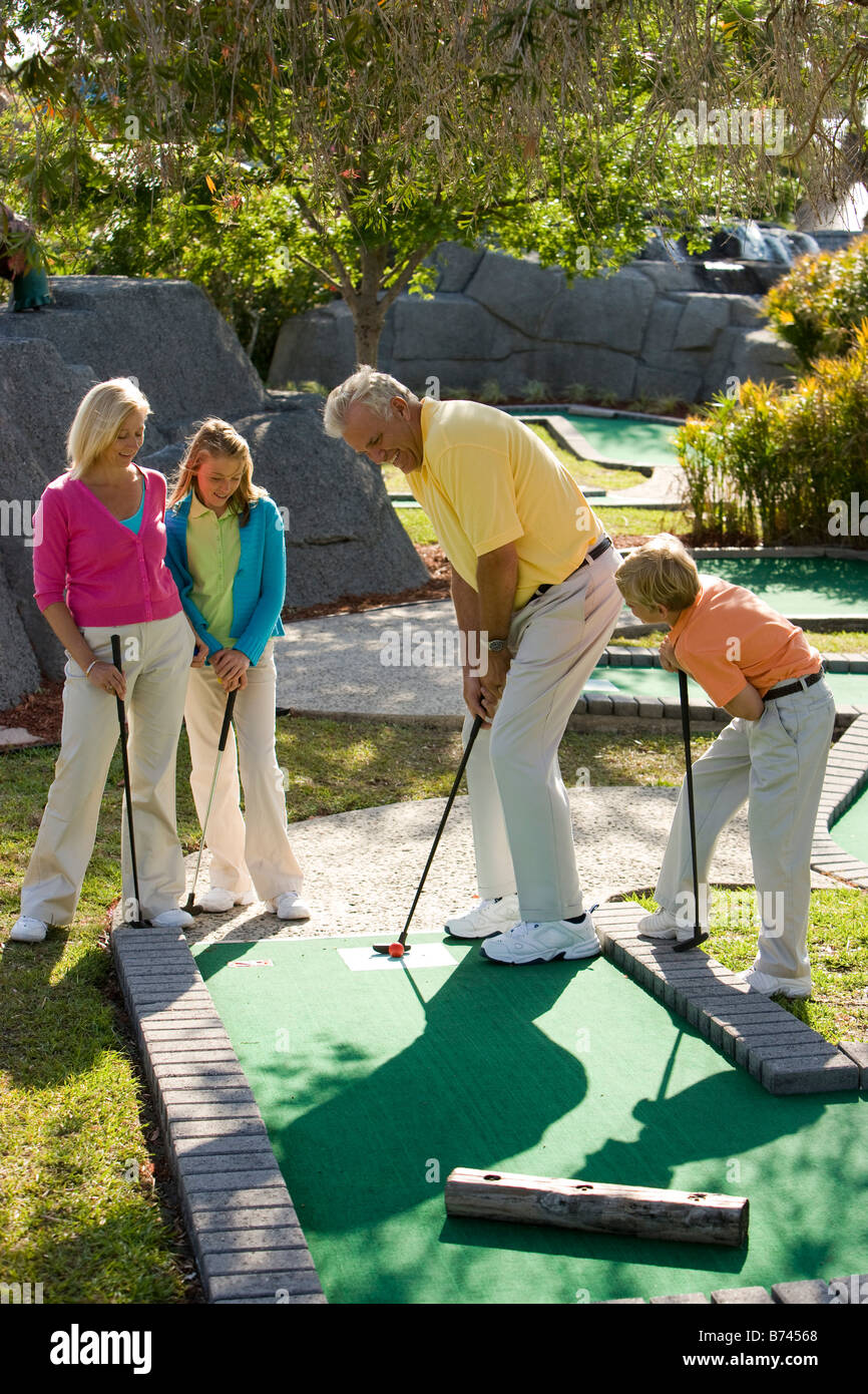 Family playing miniature golf Stock Photo - Alamy