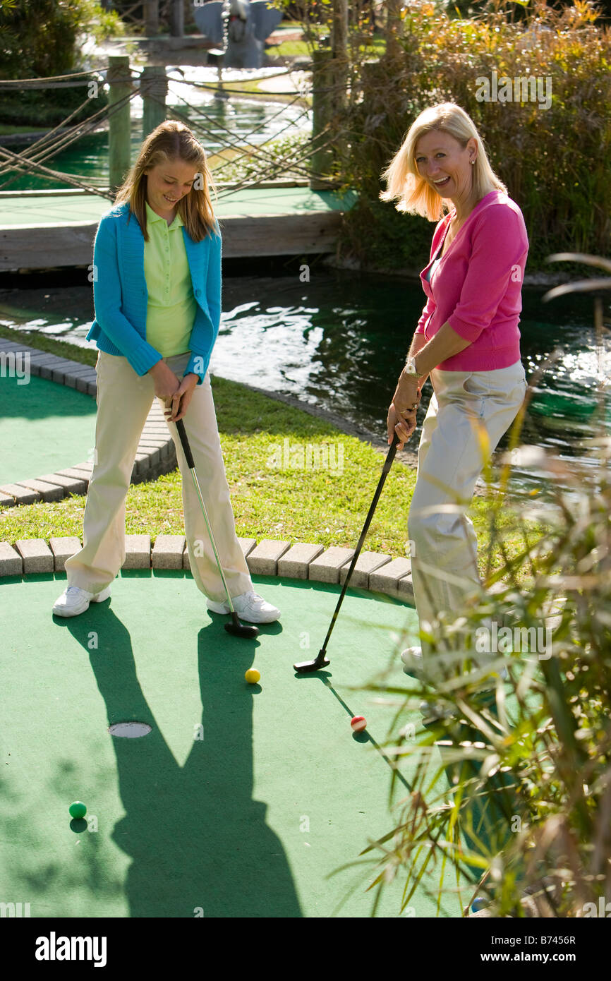 Mother and daughter playing miniature golf Stock Photo - Alamy