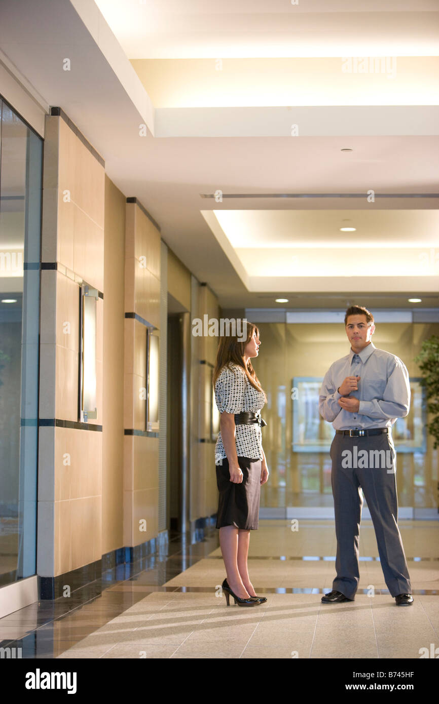 Two business colleagues talking in office corridor Stock Photo - Alamy