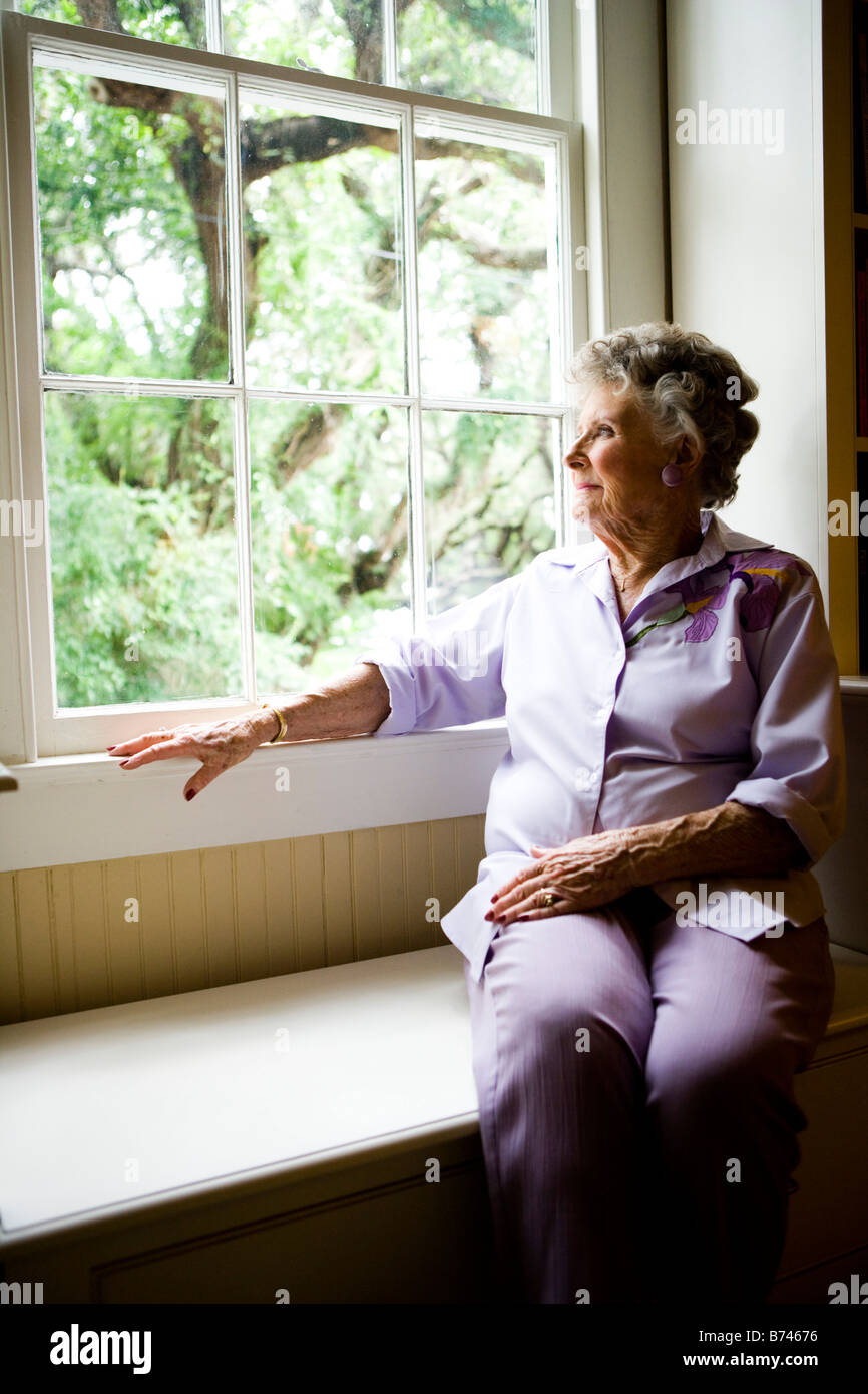 Woman sitting by a window hi-res stock photography and images - Alamy